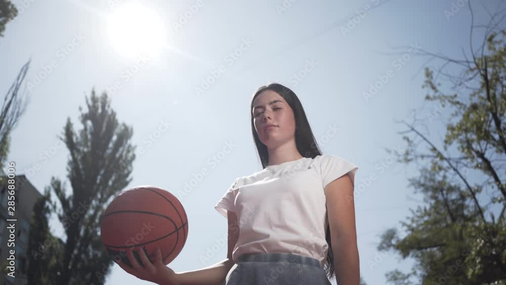 Portrait of pretty brunette girl throwing the ball up. Concept of sport ...