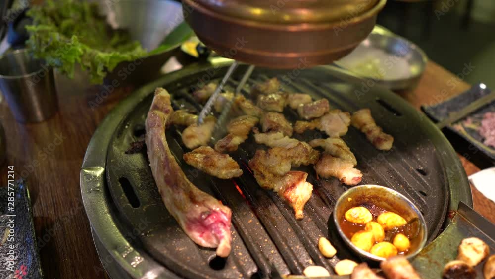 Process of preparing korean bbq samgyopsal at restaurant. Closeup on ...