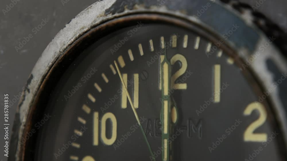Close-up of the dial of a vintage aviation clock. The arrows show ...