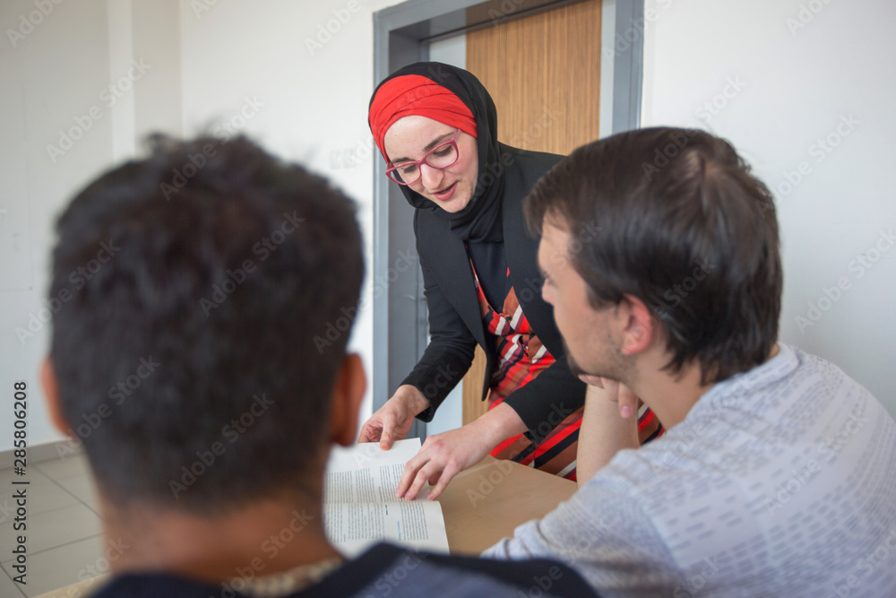 Female muslim professor explain lesson to students and interact with ...