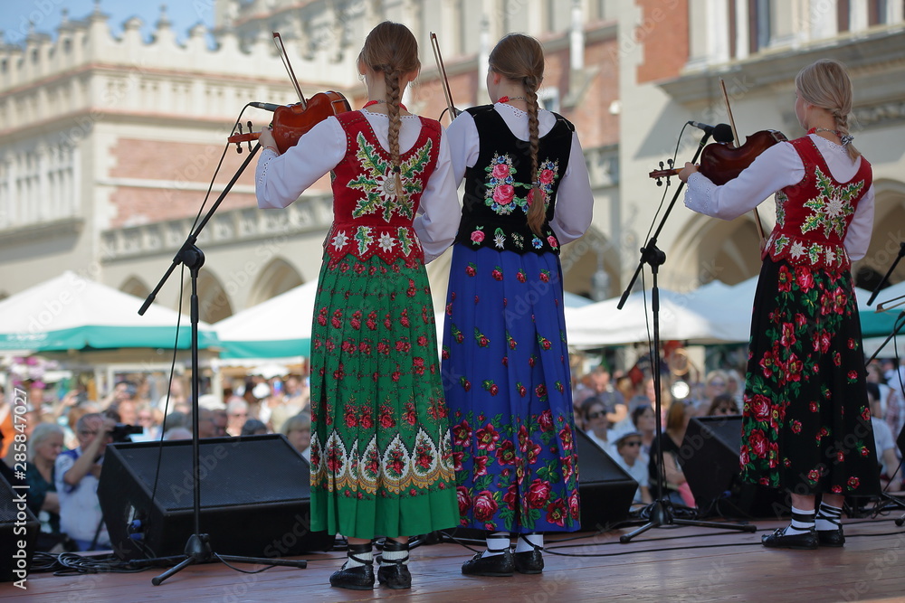 Female band on stage, three young Polish girls play violin, dressed in ...