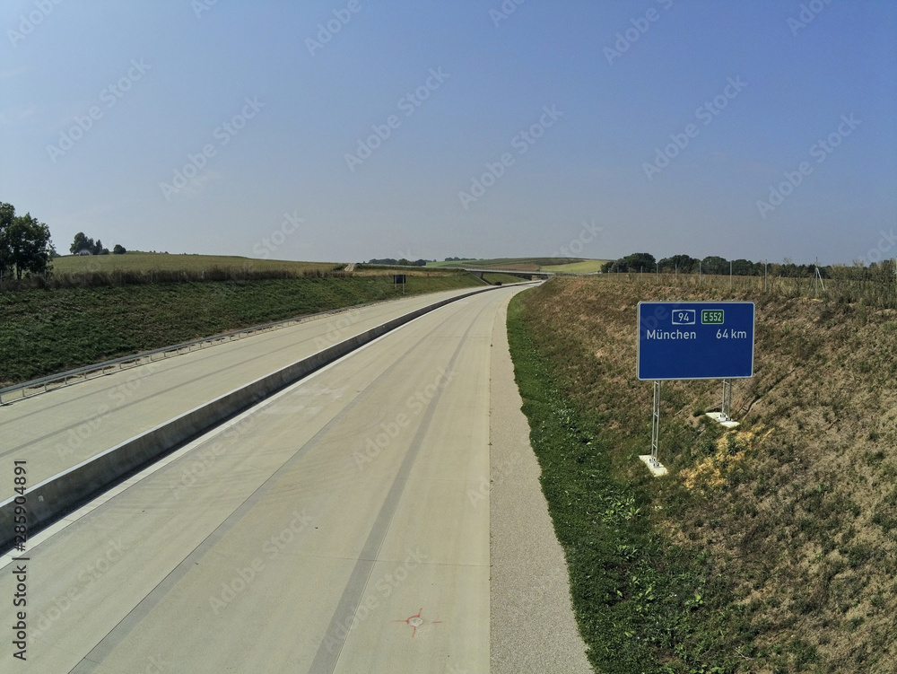Autobahn A94 at Heldenstein with street sign distance to Munich 64 Km ...