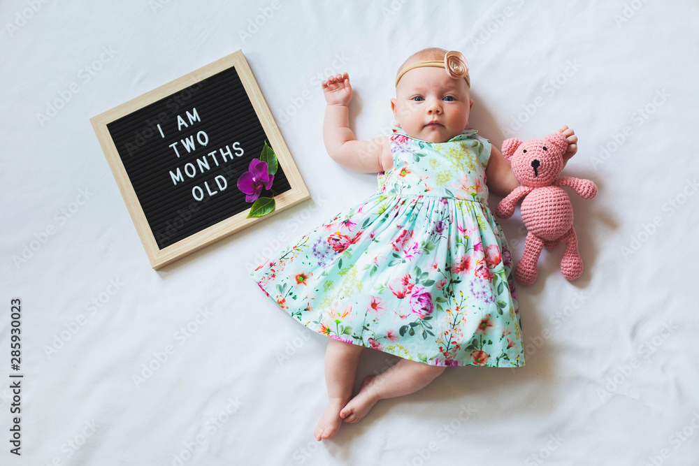 Two months old baby girl wearing floral dress and headband laying near ...