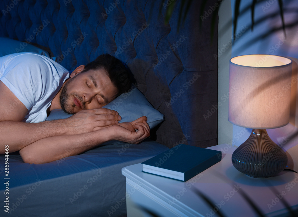 Handsome man sleeping on pillow in dark room at night. Bedtime Stock ...