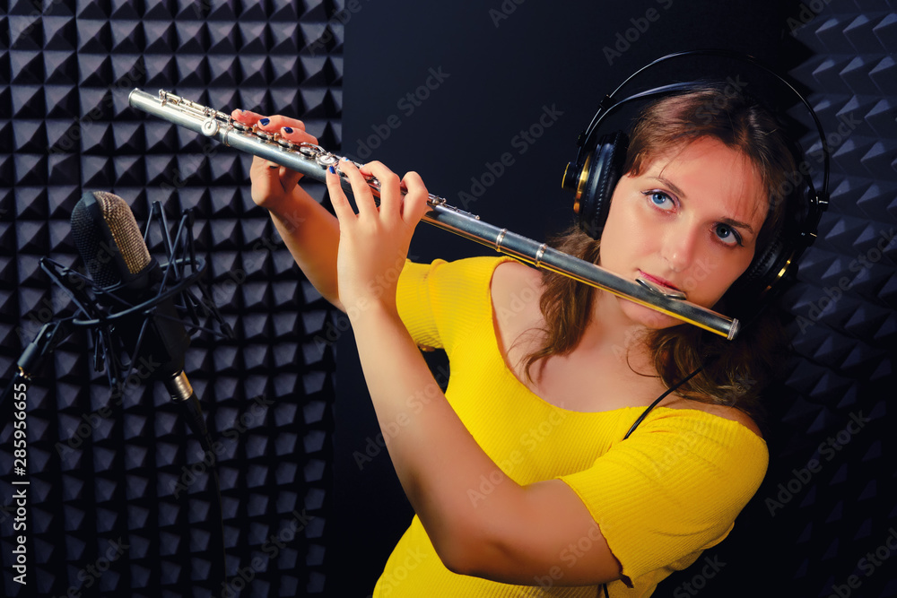Woman flutist plays Boehm flute, black background. Female flute player ...
