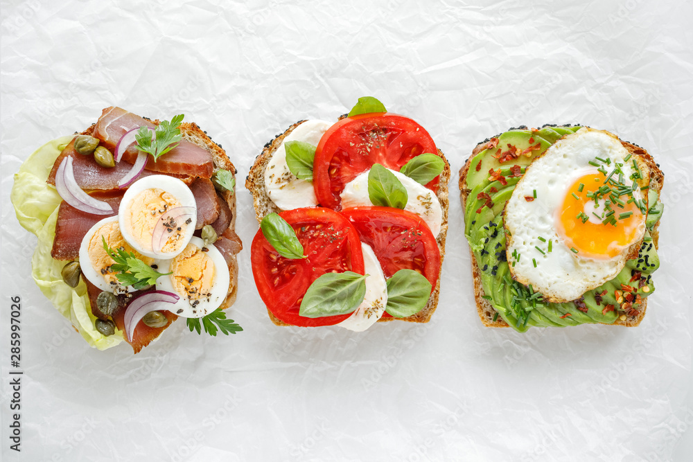 Variety of open sandwich, wholemeal bread slices with various toppings ...
