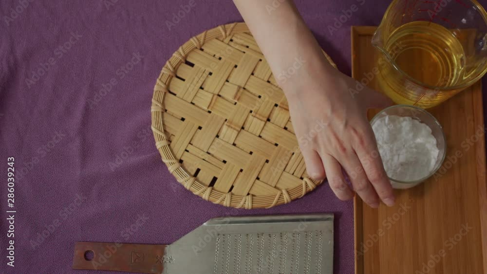 a Japanese female chef picking up potato starch from her table ...