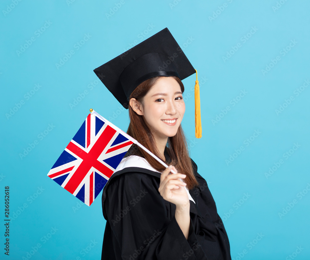 happy Young female graduation student showing the United Kingdom flag ...