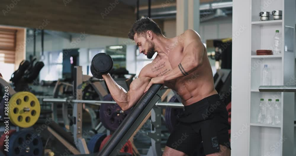 Handsome guy in a gym class bodybuilding concept lifting up the ...