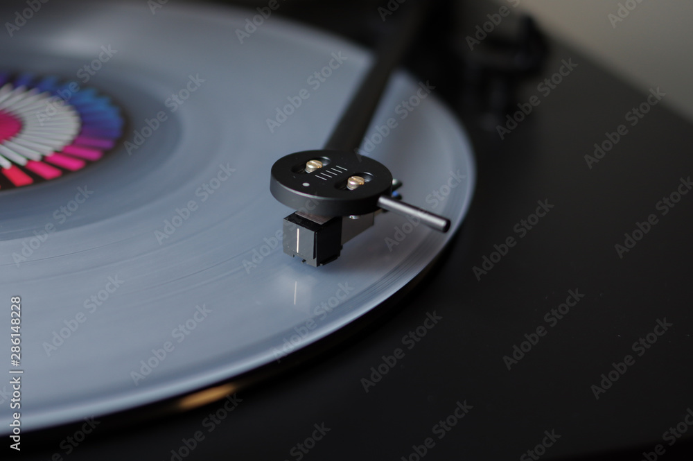 Modern round headshell with black cartridge on straight tonearm and ...