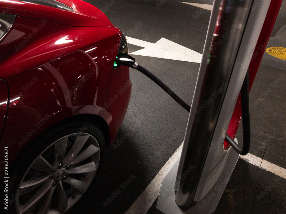 Tesla Red Model S Supercharging Electric Car Plugged In Stock Photo ...