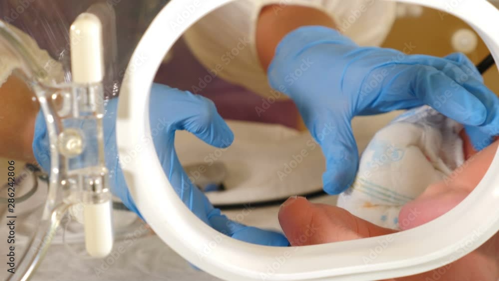 Newborn baby in Emergency Department. Doctor in blue gloves touching ...