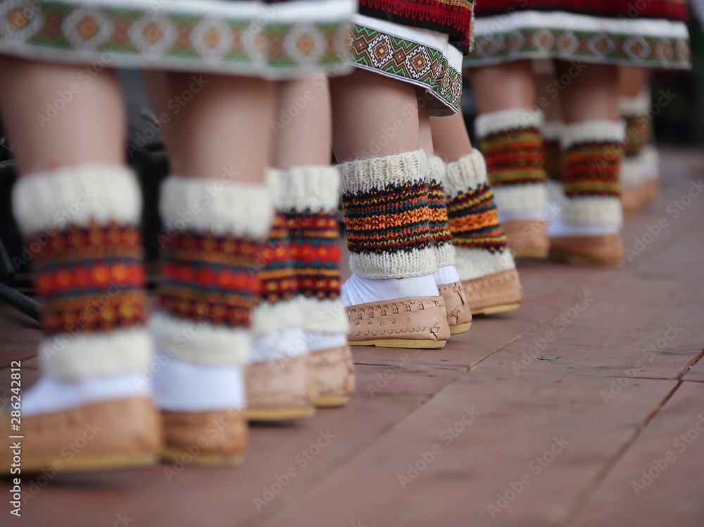 females legs in traditional regional leather folk shoes, woolen socks ...