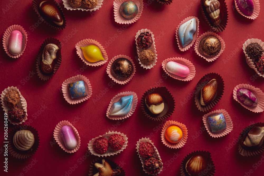 Red background with sweet chocolate candies Stock Photo | Adobe Stock