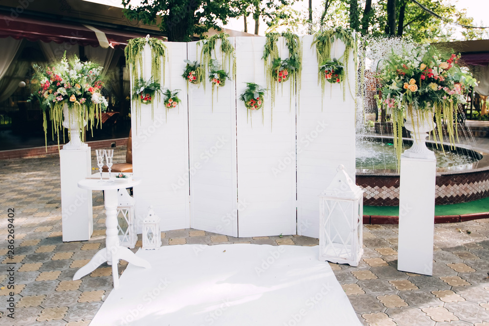 beautiful wedding photo zone in the park with fountains in the shade, a ...