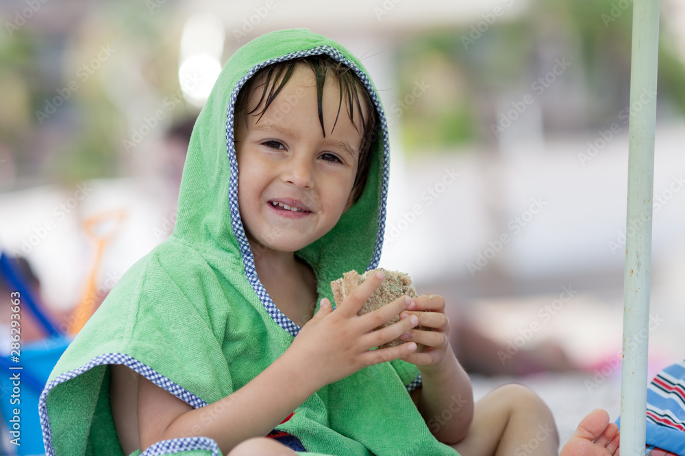 Cute boy, eating sandwich on the beach Stock Photo | Adobe Stock
