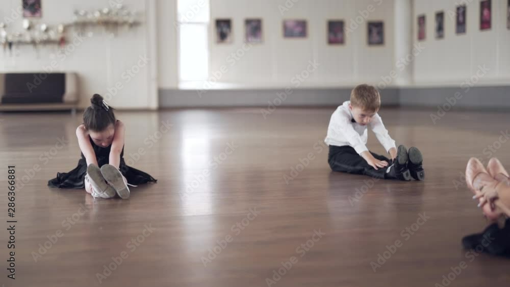 Sliding low shot Teacher coach teaching a cute boy and a girl how to ...