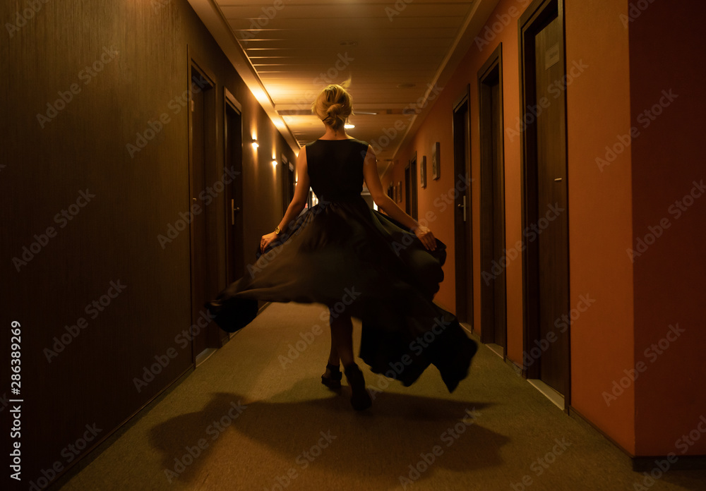 Luxury girl in black dress at night in the hotel corridor. Stock Photo ...
