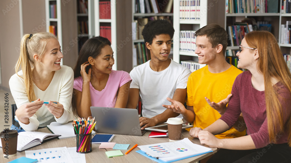 Group of multinational teenagers working on project at library Stock ...