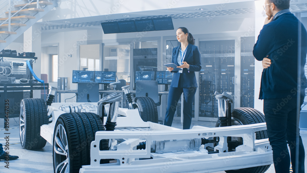 Automotive Design Engineers Talking while Working on Electric Car ...