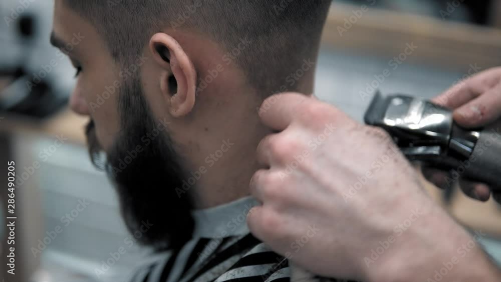 Close-up view on male's hairstyling in a barber shop with professional ...