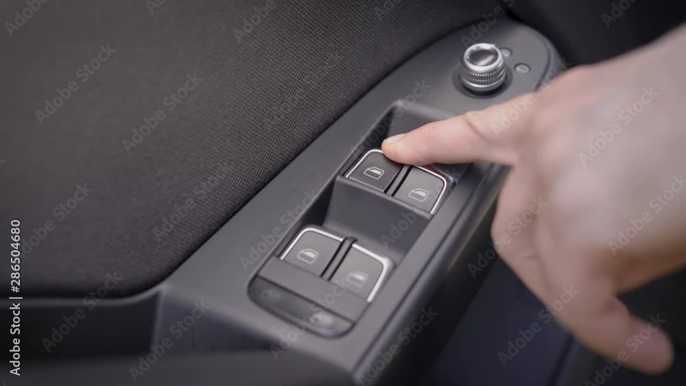 A man opens and closes a car window with an electric drive. Automatic ...