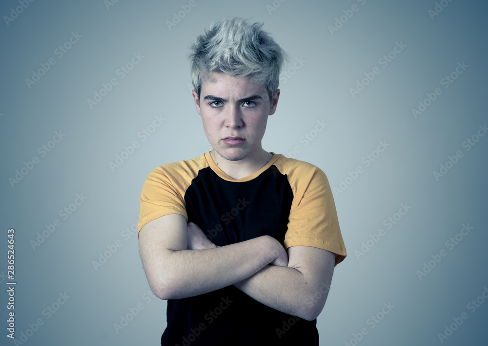 Portrait of a young transgender teenager boy with angry face looking ...