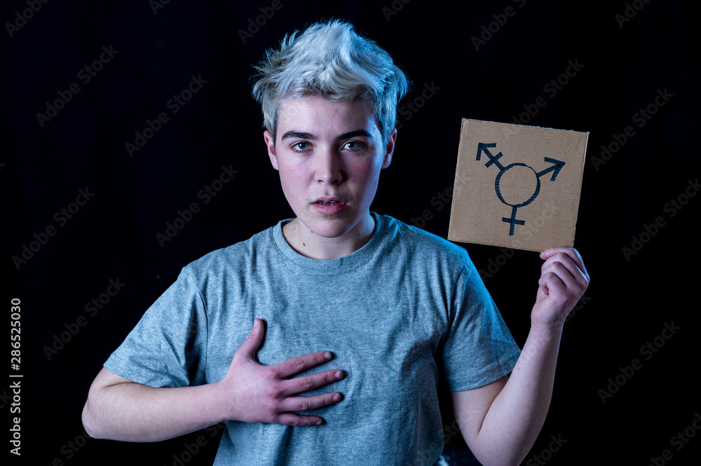 Portrait of happy proud and confident trans teenager man holding ...