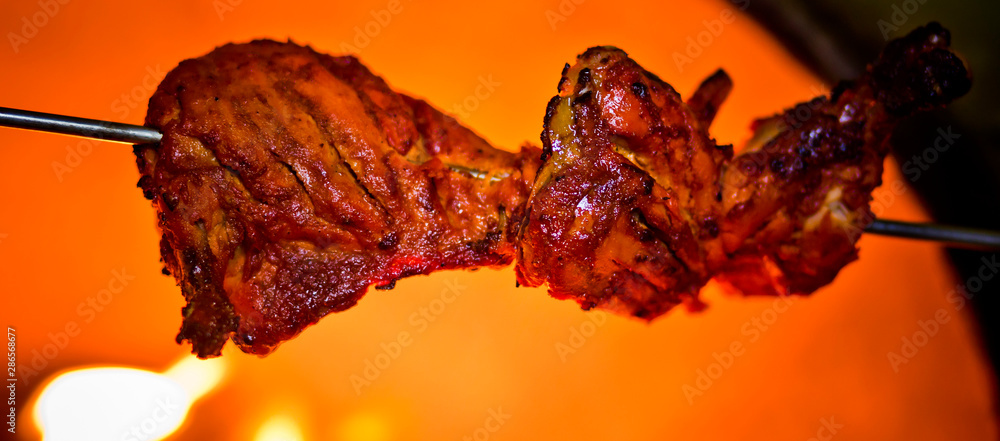 Using on an iron stick is roasting chicken in the oven. Stock Photo ...