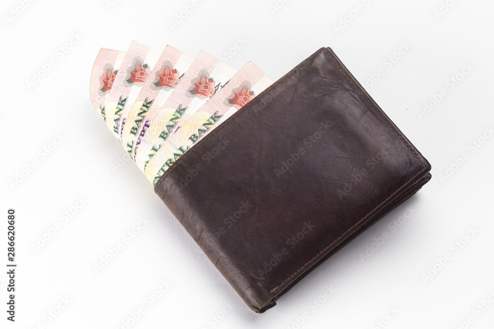 200 Egyptian pound bills in a dark brown wallet isolated on a white ...