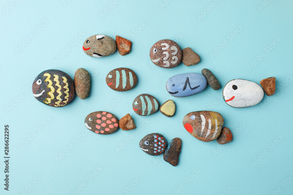 Multicolored stones and creative fish made of stone. The painting is ...