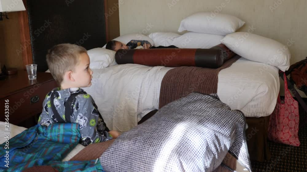 Two cute boys lying around in a hotel room in the morning Stock Video ...