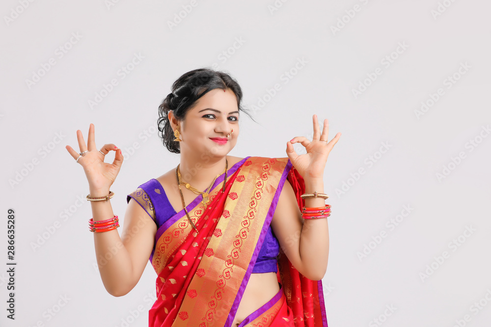 Young Indian woman wearing sari and making OK sign against white ...