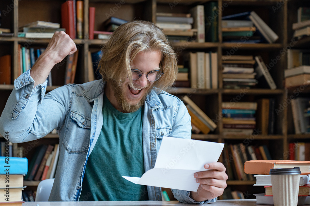 Excited happy university student winner holding reading admission ...