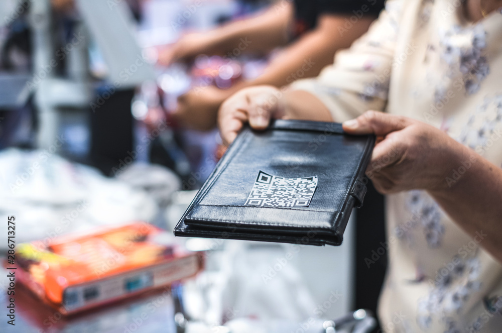 Seller or trader handing QR code to customer for moibile online payment ...