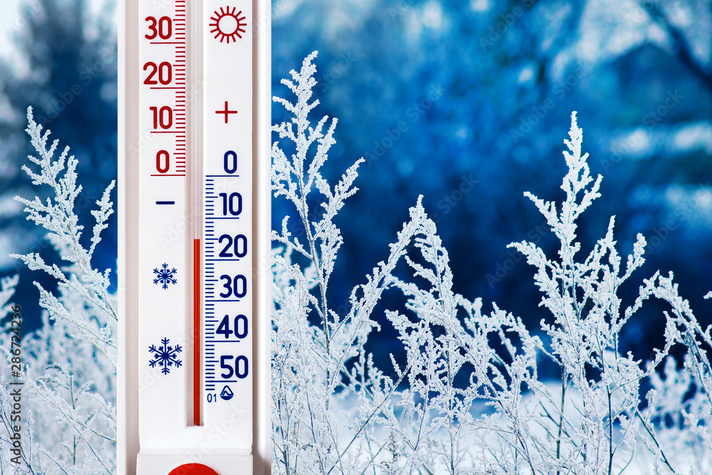 The thermometer on a background of winter landscape shows 15 degrees of ...