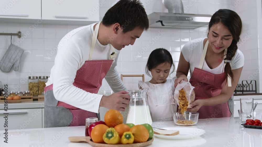 Happy Asian family make a cooking. Father and Mother make breakfast ...