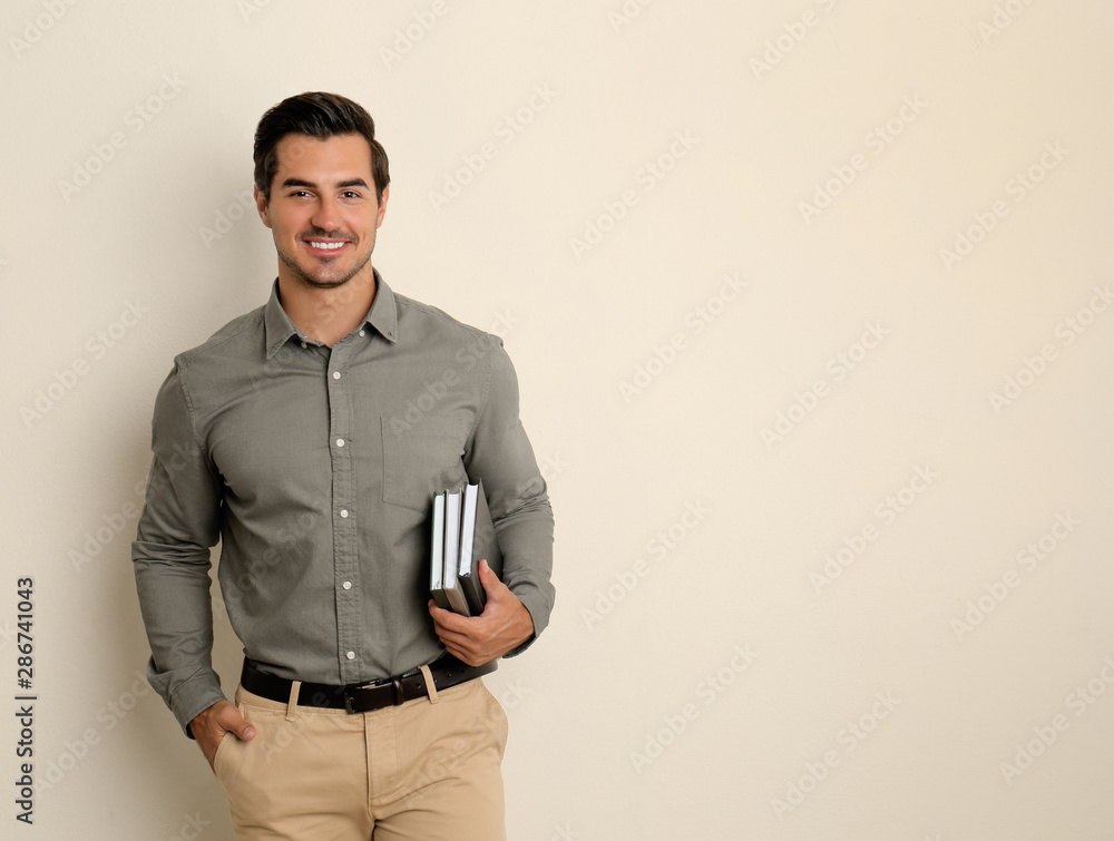 Young male teacher with books on beige background. Space for text Stock ...