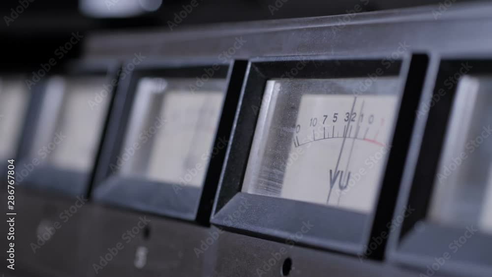 Side view of working standard volume indicators, needles moving from ...