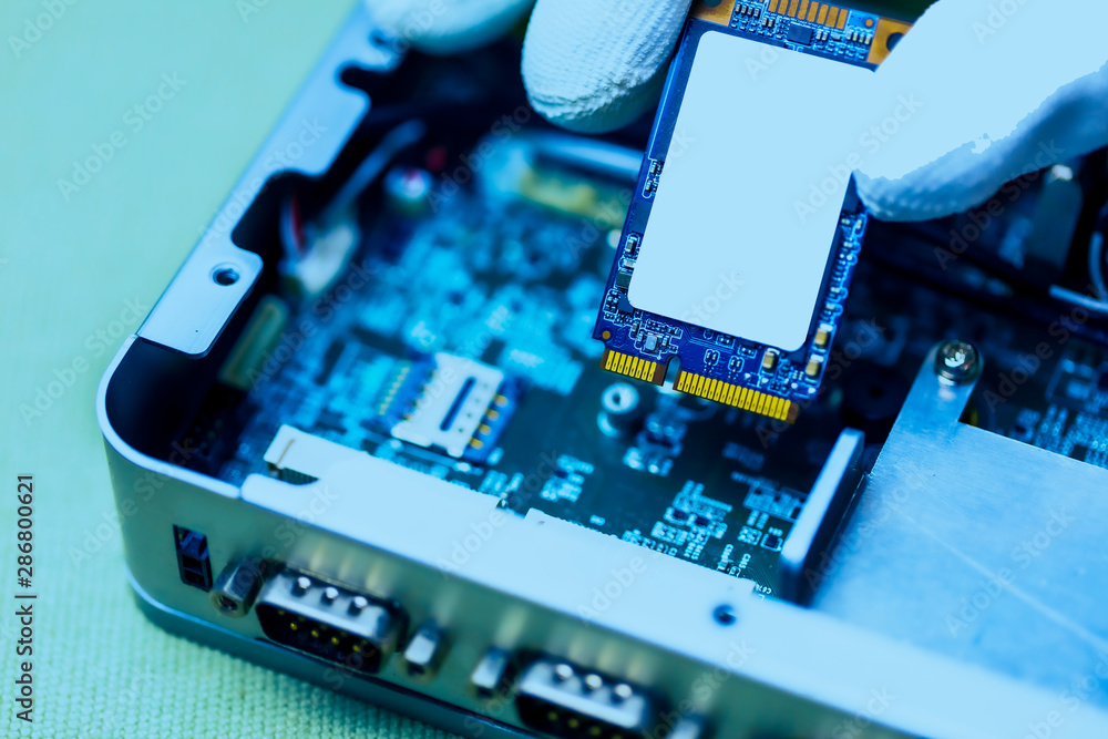 Hand holding tiny electronic circuit board inserting to the socket ...