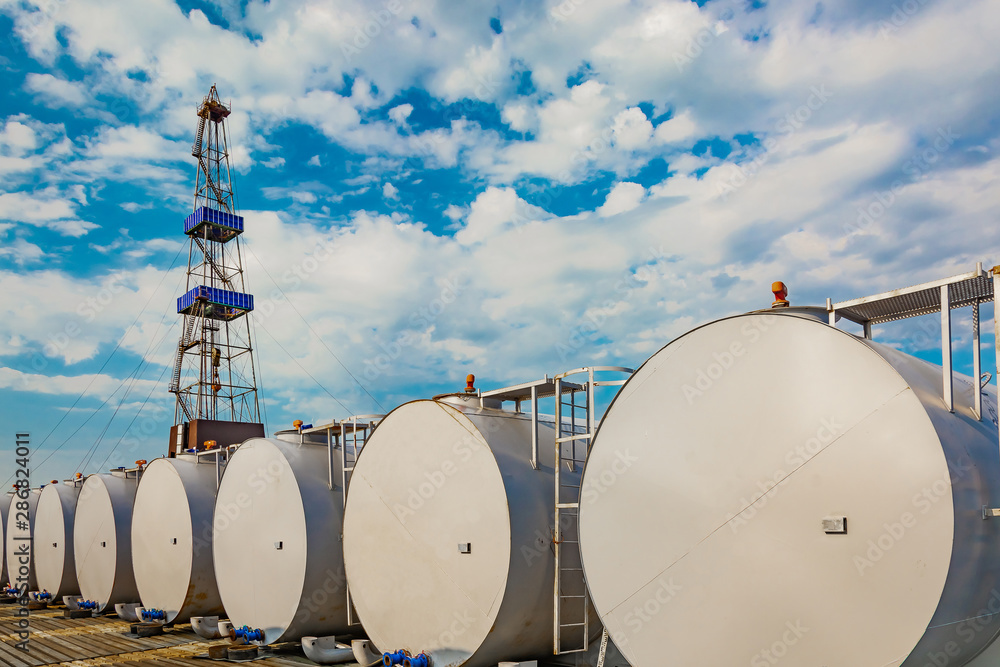 In the foreground are gray cylindrical tanks for storing oil and fuel ...