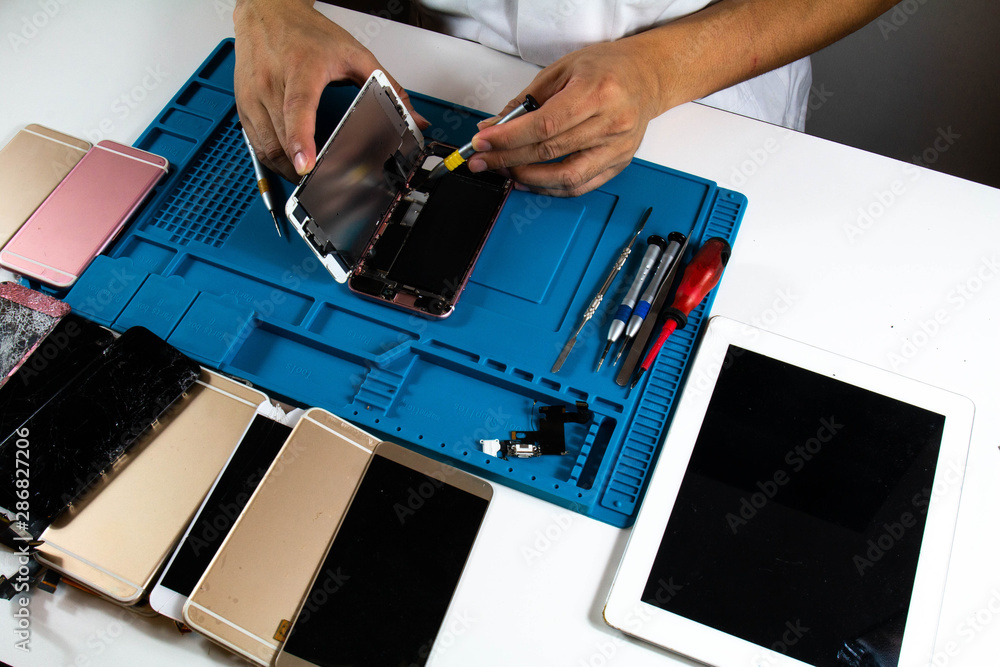 Foto de Change mobile phone batteries. The mobile phone repairer is ...