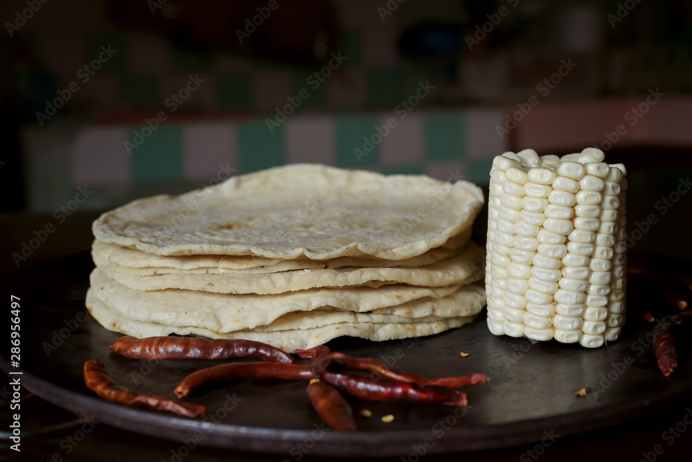 En la mesa hay muchas tortillas de maíz algunos pedazos de elote y ...