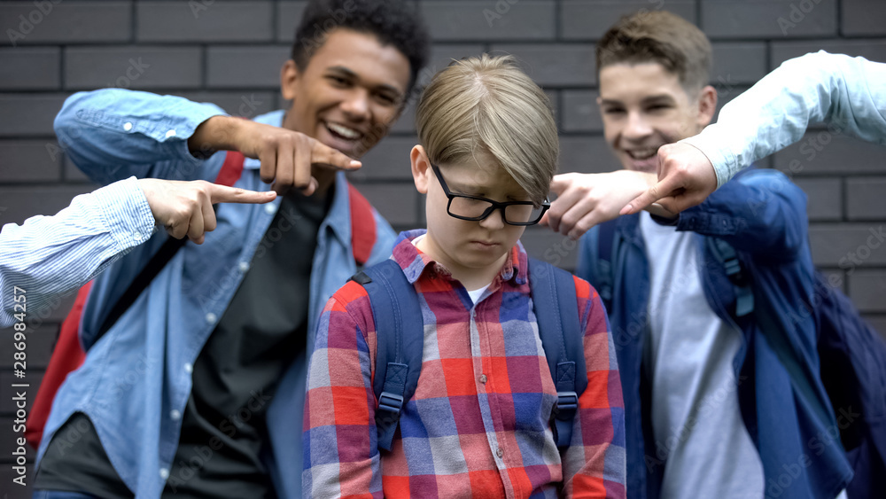 Evil schoolchildren pointing fingers at junior boy, mocking nerd ...