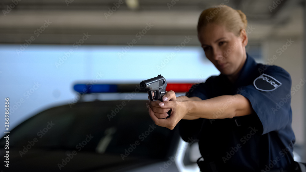 Female police officer aiming gun, detention on crime scene, murder ...