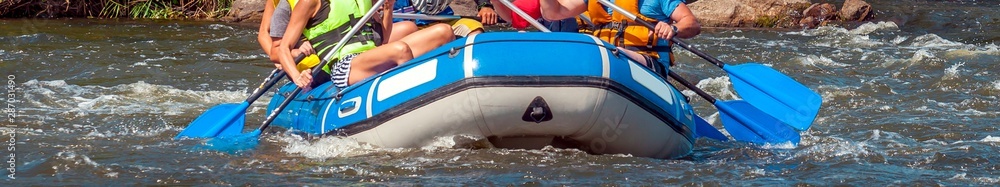 Rafting trip. Close up view of oars with splashes of water. Rowers make ...