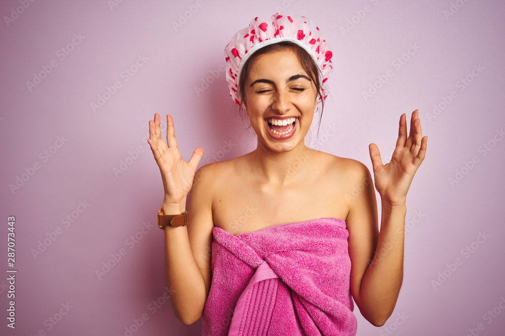 Young beautiful woman wearing a shower towel after bath over pink ...