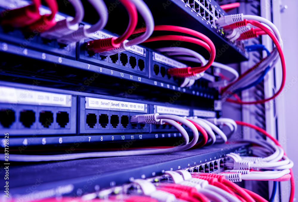 Network switch and ethernet cables in red and white colors. Data Center ...