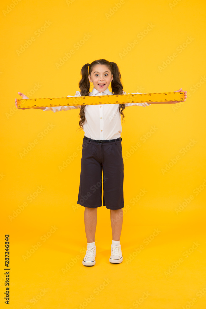 What a long ruler. Surprised little student holding rigid wooden ruler ...