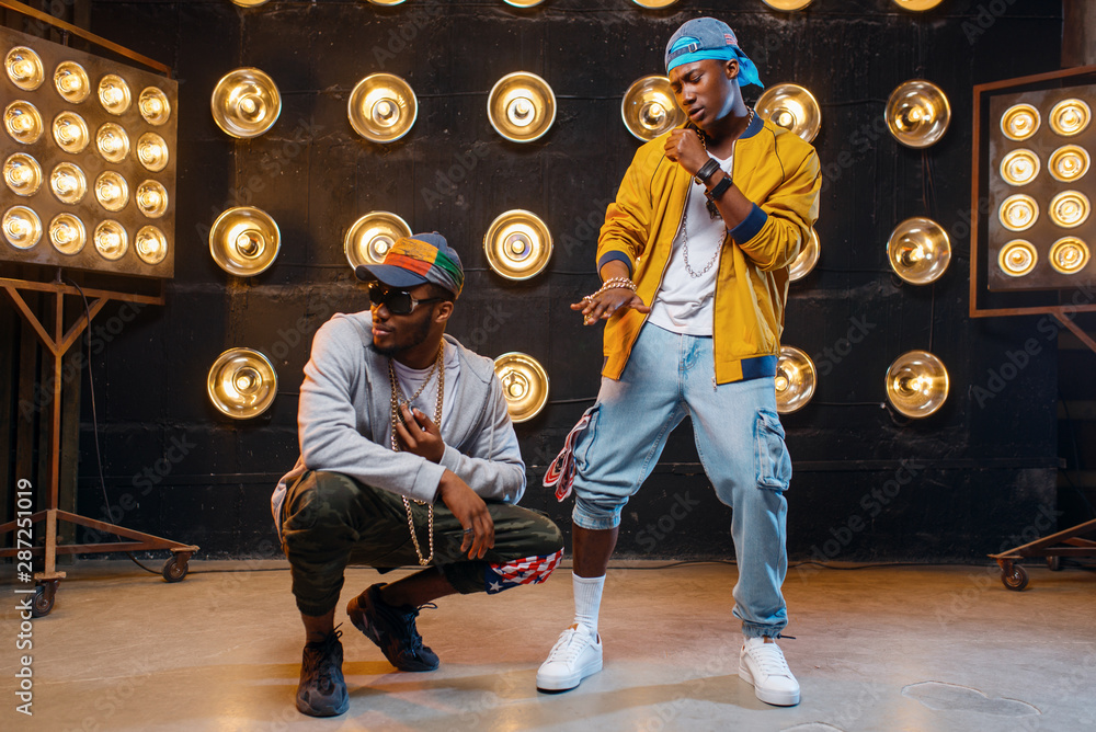 Rappers in caps dance on stage with spotlights Stock Photo | Adobe Stock